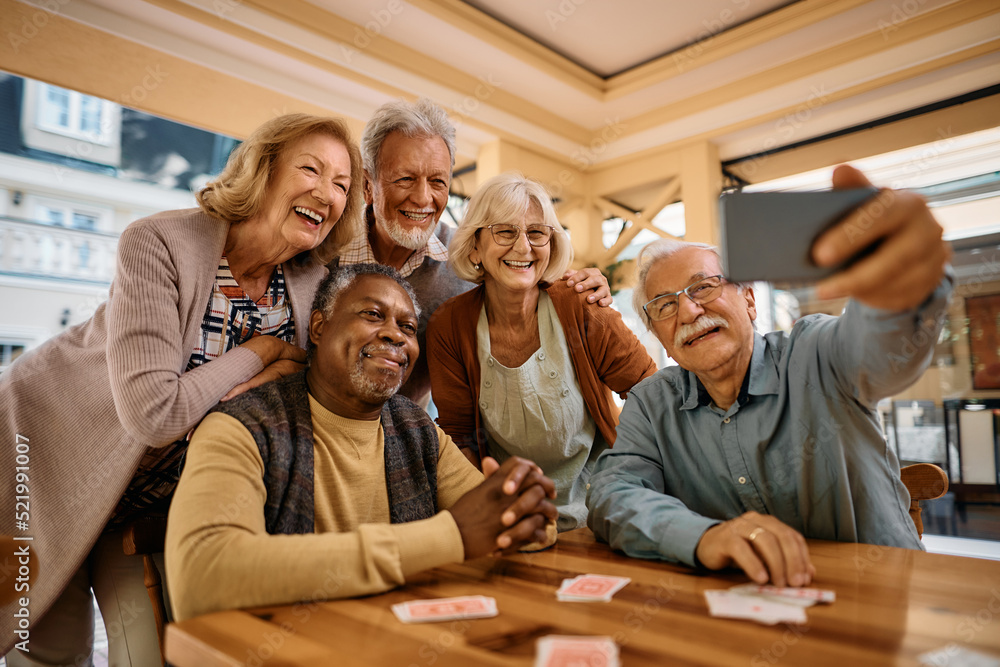 Cheerful senior have fun while taking selfie at retirement community ...