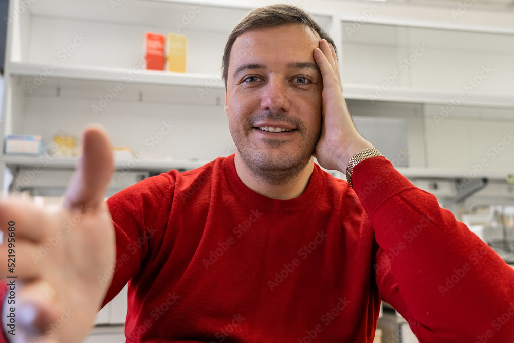 Chemical lab researcher, man speaking, looks into camera in biomedical ...