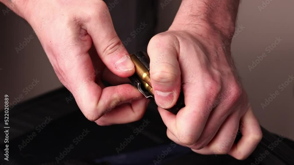 Male hands loading Kalashnikov assault rifle magazine with cartridges ...