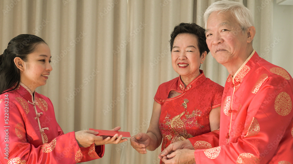 Asian family gathering Chinese New Year celebration in red traditional ...