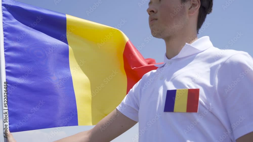 Young man waving the Romanian flag. The Romanian flag is waving in the ...