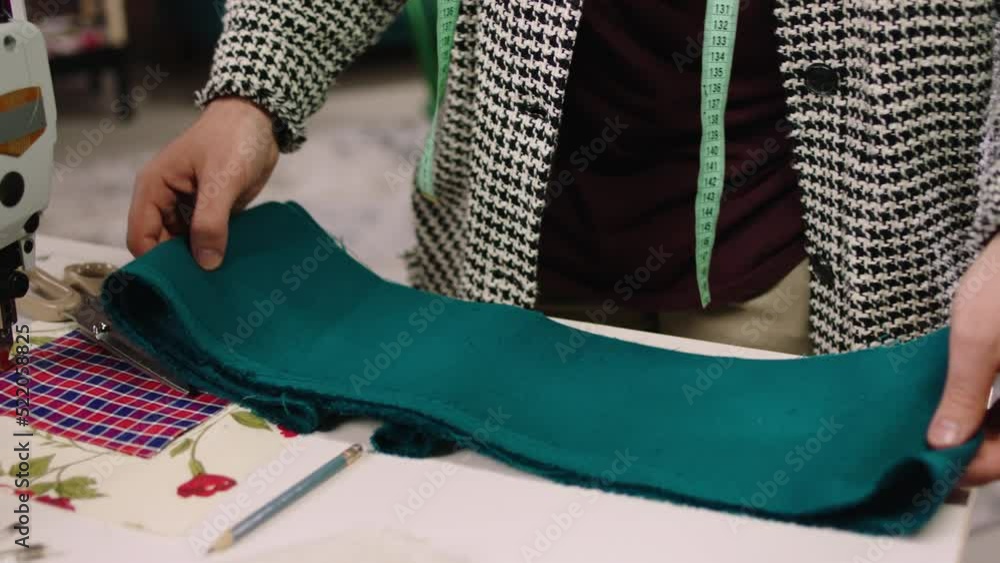 Closeup taking video details of a man using the fabrics to start sew ...