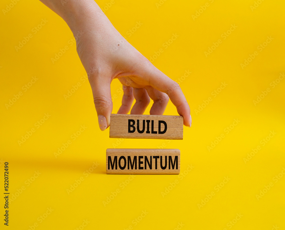 Build momentum symbol. Wooden blocks with words Build momentum ...
