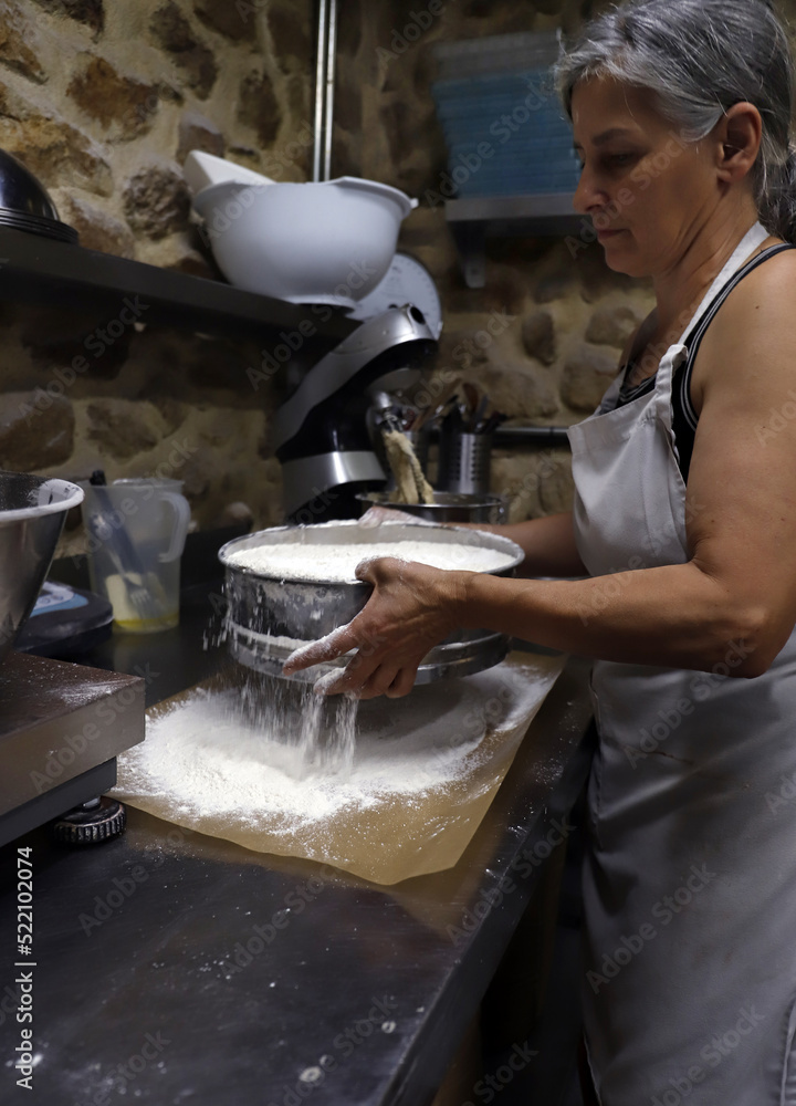 mujer repostera tamizando harina Stock Photo | Adobe Stock