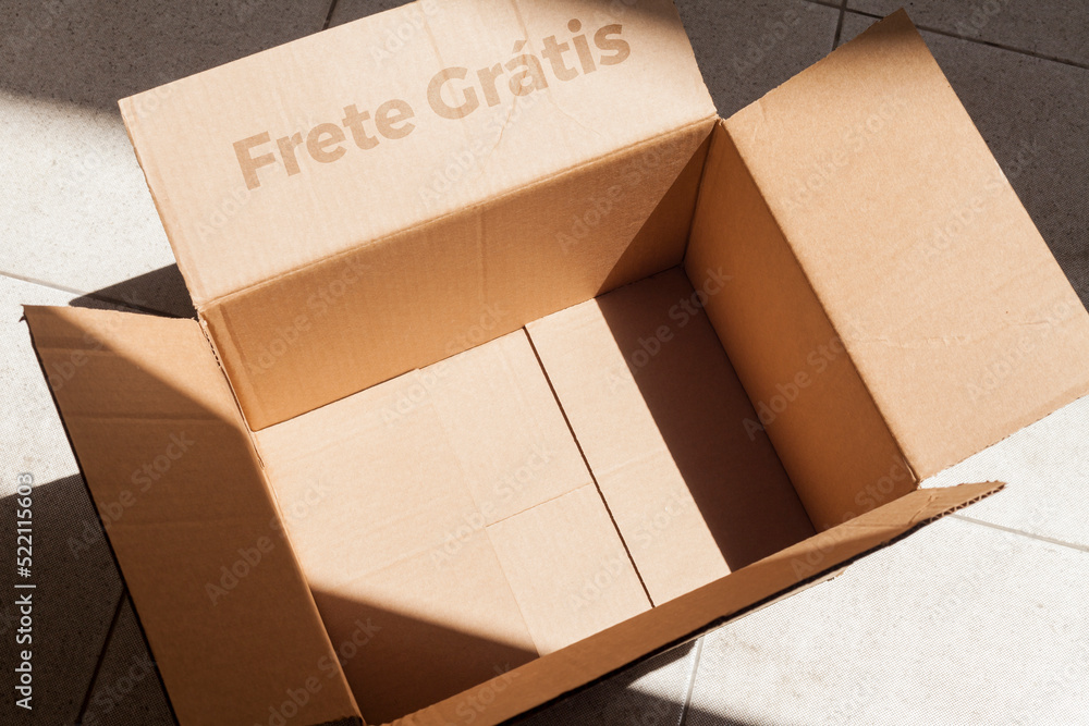 Open cardboard box with sunlight written on frete gratis. Putting ...