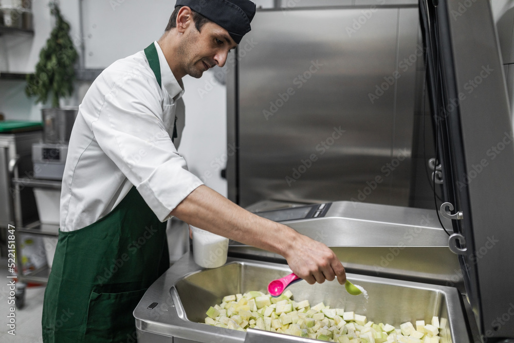 chef cooking vegetables in the industrial fryer in a kitchen Stock ...