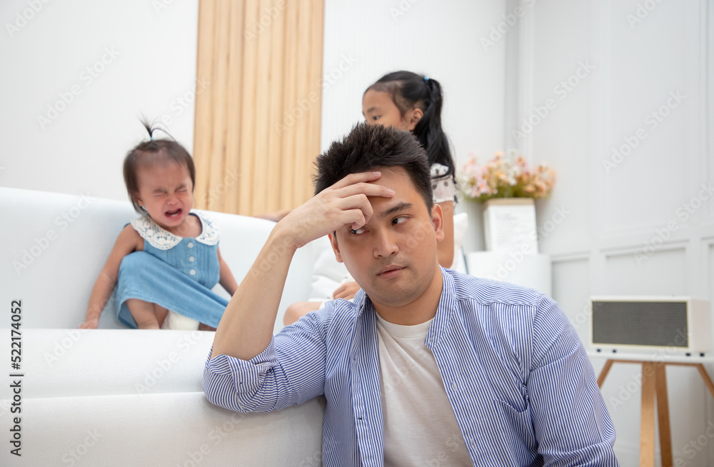 Asian father with his crying little daughter on sofa. Fatherhood and ...