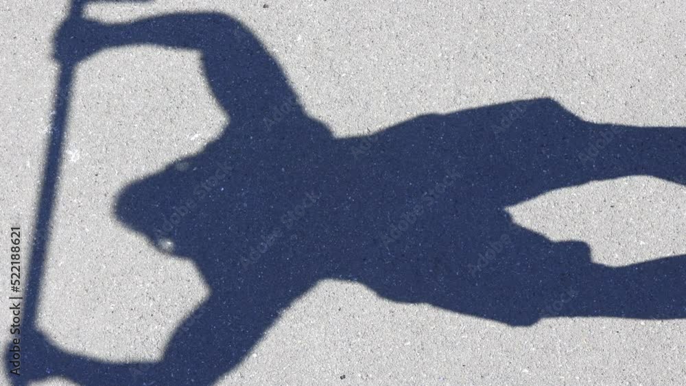 Shadow of strong muscular athlete who pulls up on horizontal bar in the ...