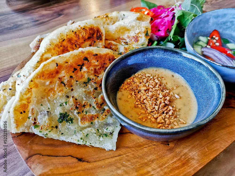 Garlic naan roti lightly grilled flat bread with peanut satay sauce and ...