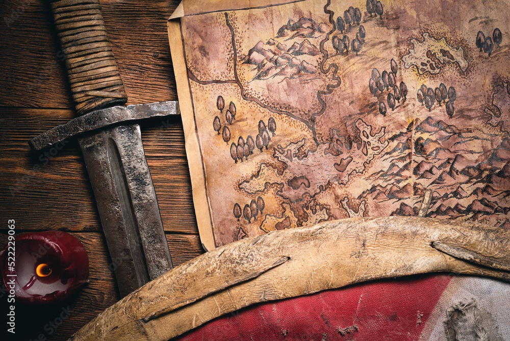 Ancient map, sword and shield on the flat lay table background. Stock ...