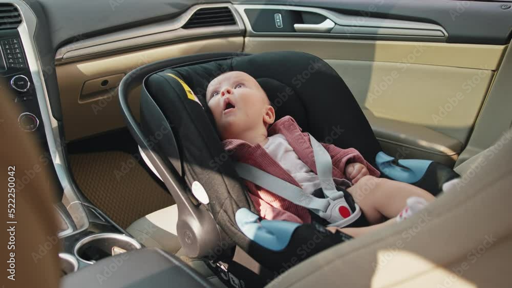 Shooting of nice little boy sitting in baby car seat. Portrait of child ...