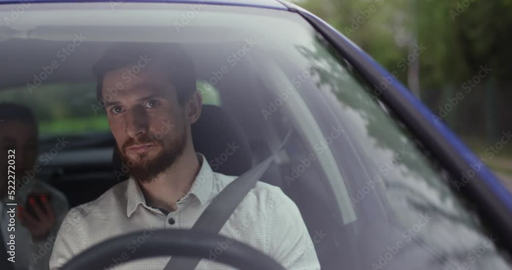 Handsome young man driving a car with passanger on back seat Stock ...