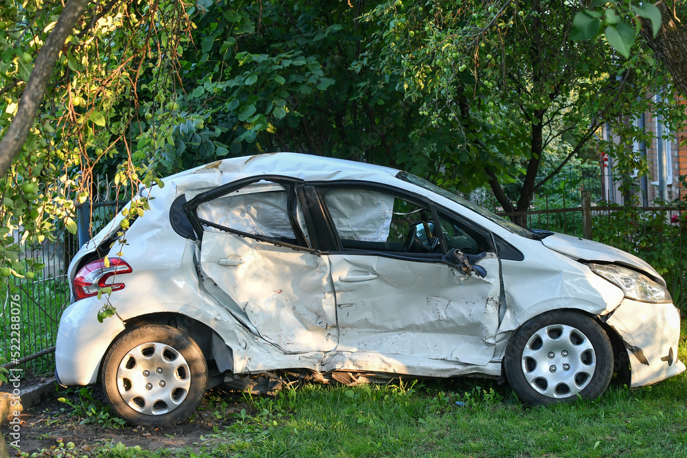 White microcar heavily damaged on the side, with airbags exploded. Car ...