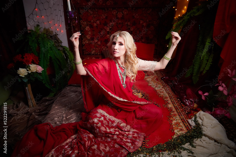 A beautiful European girl looking like an Arab woman in a red room in a ...