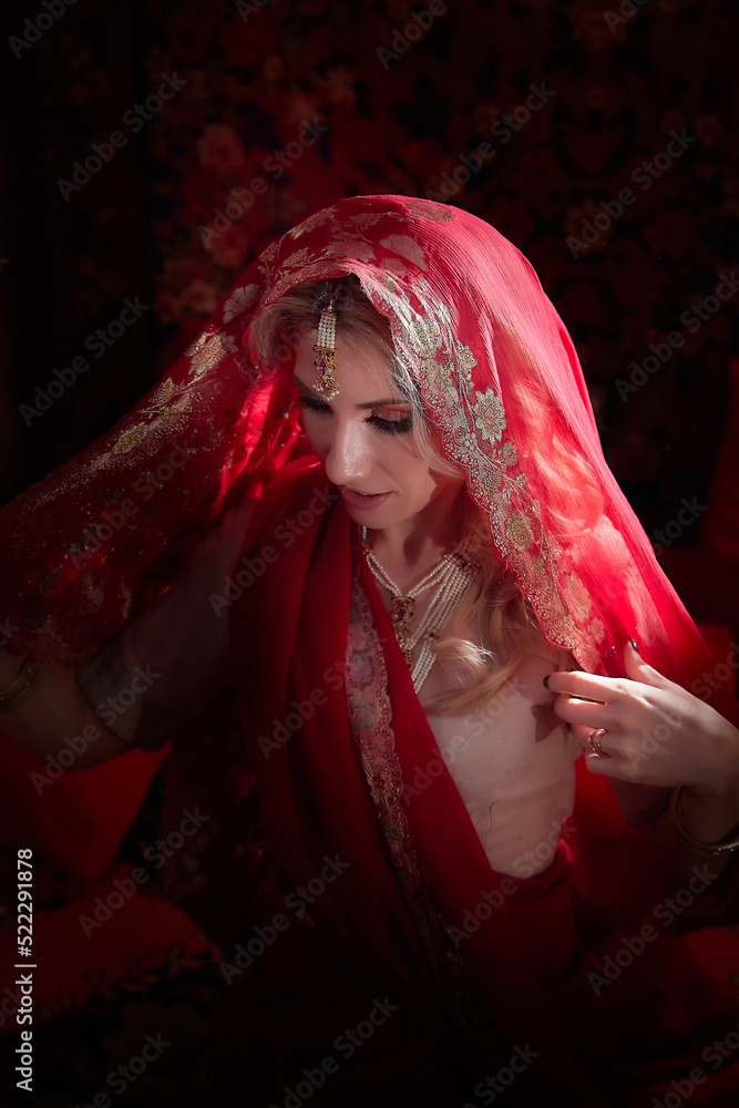 A beautiful European girl looking like an Arab woman in a red room in a ...