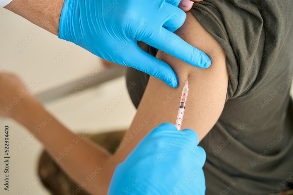 Nurse giving an injection to the arm of a young woman Stock Photo ...