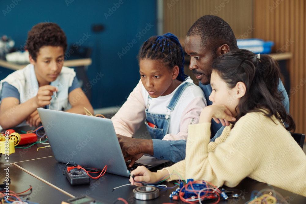 Portrait of black teenage girl using laptop in school during ...