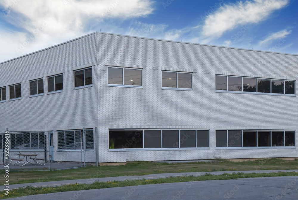 Exterior corner of nondescript two story white brick office or factory ...
