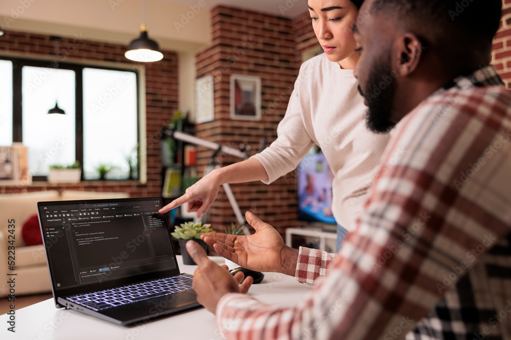 Programmers couple coding security firewall on laptop, using html and ... Programmers couple coding security firewall on laptop, using html and ...