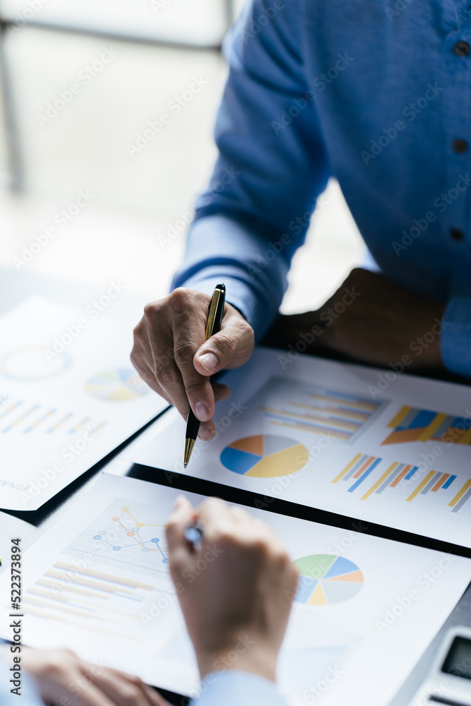 Business team reviewing a diagram or chart and financial reports for a ... Business team reviewing a diagram or chart and financial reports for a ...