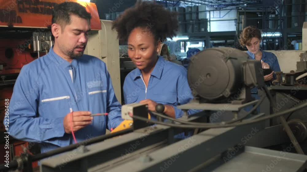 Vidéo Stock Asian male and female African American engineers in safety uniform work by ...