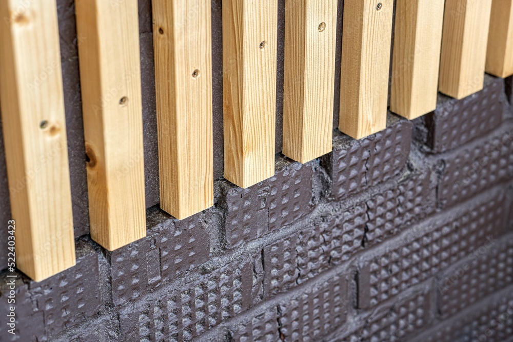 Building wall decorated with stylish wooden slats made of thin light ...