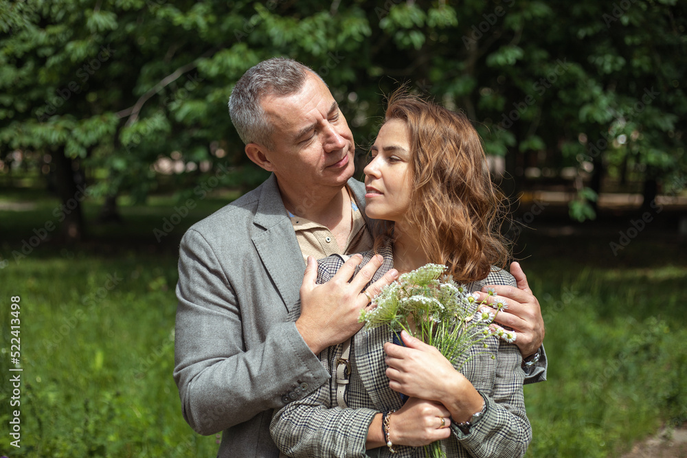 Portrait of loving couple gently hugging in green park on sunny day ...