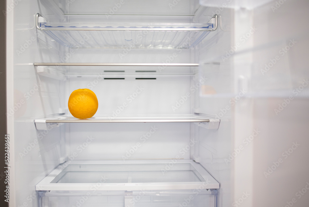 An orange lying against the background of a white empty clean ...
