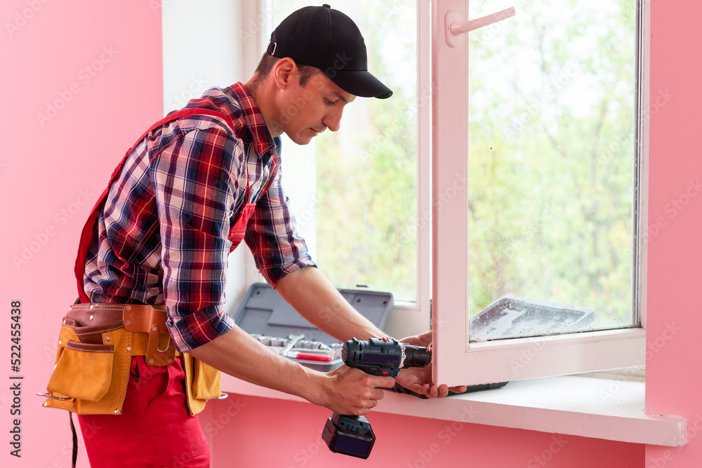 handyman adjusting white pvc plastic window indoors. worker using ...
