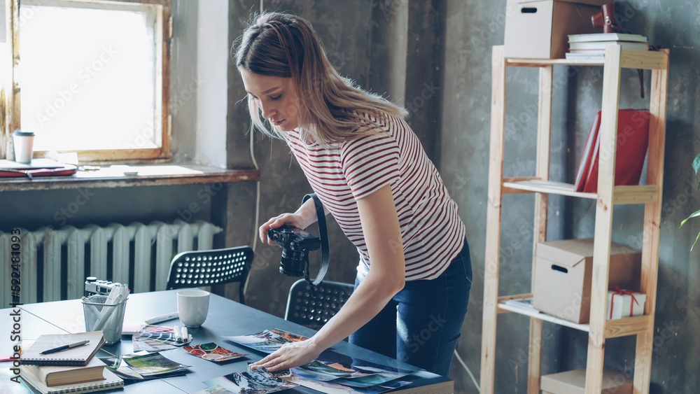 Young attractive female blogger using digital camera to shoot colourful ...