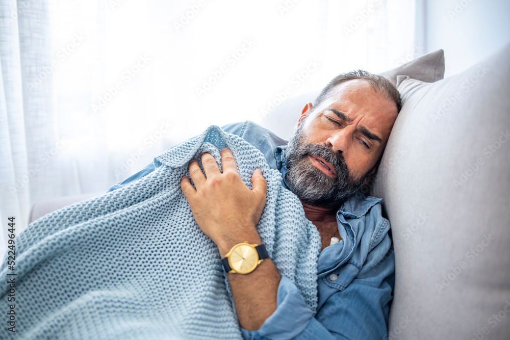 Sick day at home. Handsome Man has fever and common cold. Cough ...