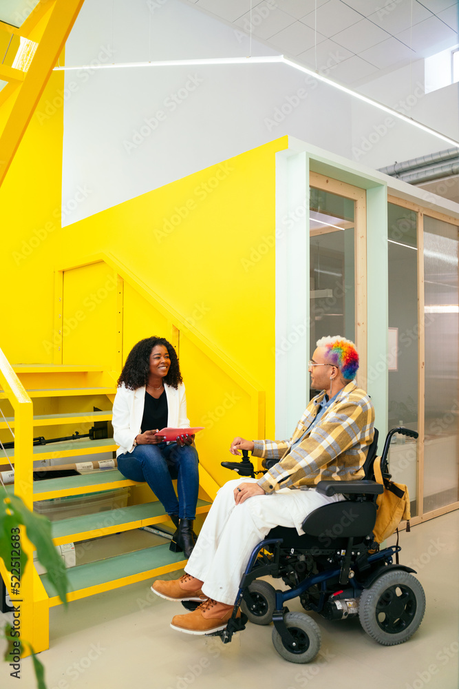 Black woman with disabled coworker in staircase Stock Photo | Adobe Stock