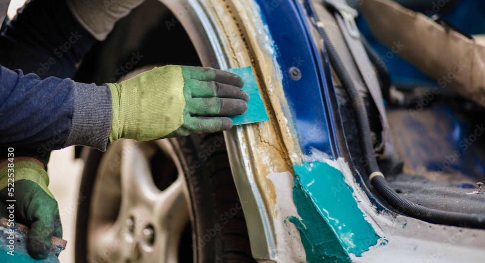 putty on a spatula by a body repair master, puttying a car body. Stock ...