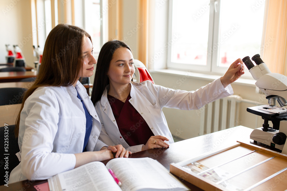 Medical students in the classroom study smears in the laboratory. Young ...