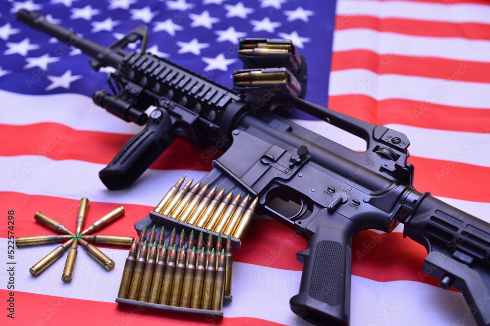 An American-made automatic carbine rifle over the US flag with stacks ...