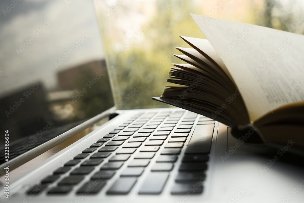 Workplace with open pc notebook device and open text book lying on a ...