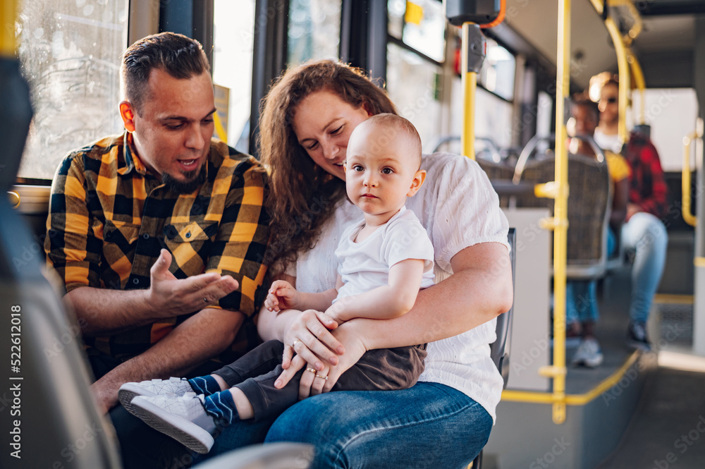 Parents riding a bus with their child during a day. Stock Photo | Adobe ...