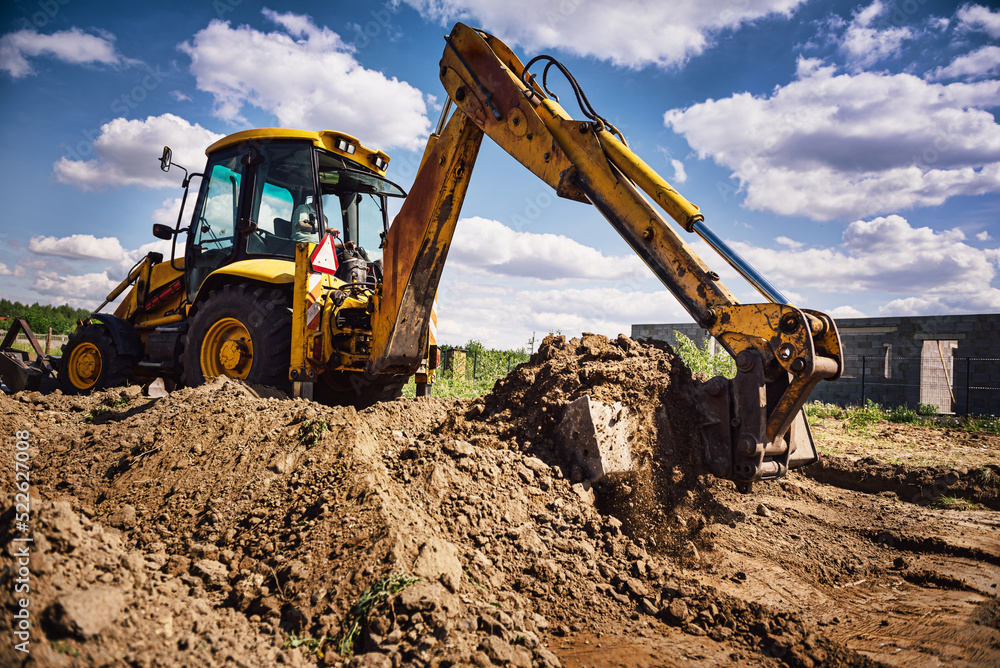 Excavator working at house construction site - digging foundations for ...