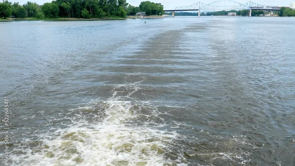 Mississippi River water being churned by the red rotating paddle wheel ...