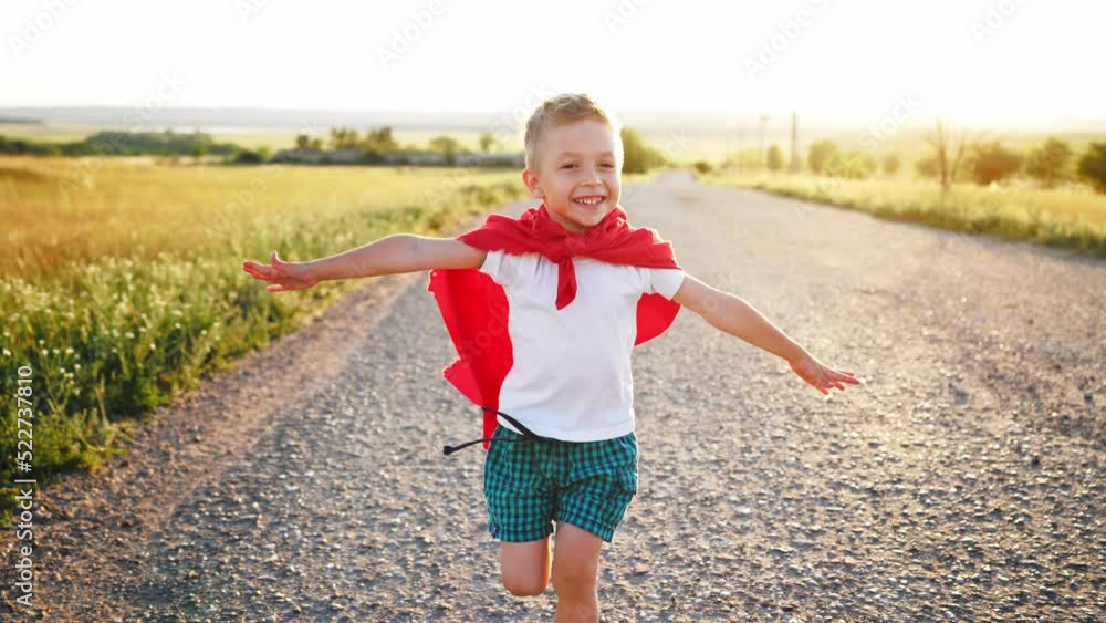 Close-up happy face of boy child running in superhero costume with red ...