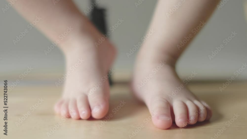 tiny barefoot baby feet of sitting child toes and heels moving on ...