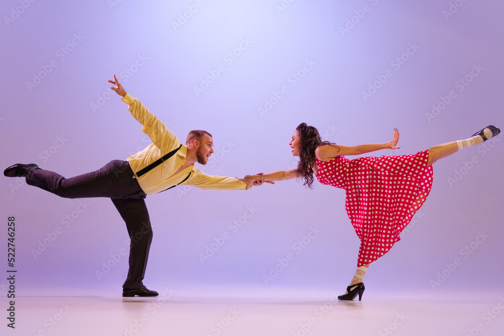 Active and emotional couple in colorful retro style costumes dancing ...