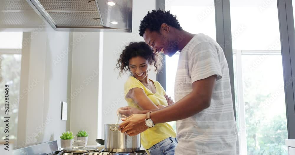 Happy black couple having fun cooking in a kitchen at home, laughing ...