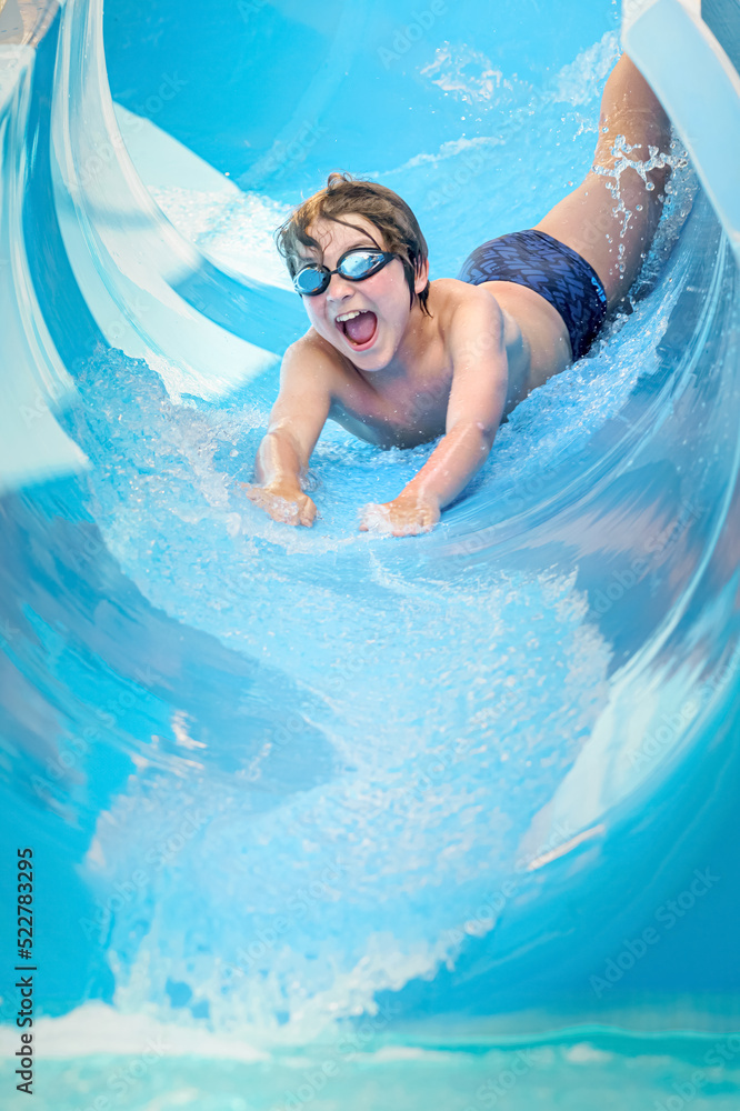 joyful boy going down the water slide in the water park, Alanya ...