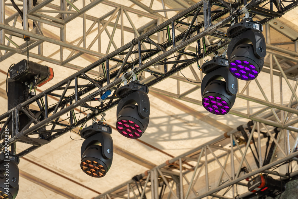 Concert spotlights suspended on metal brackets. Stock Photo | Adobe Stock