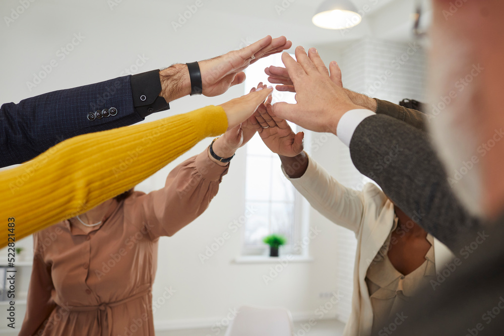 Team of diverse mixed race multiethnic business people reaching up and ...