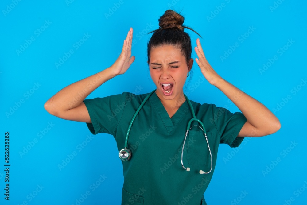 beautiful doctor woman wearing medical uniform over blue background ...