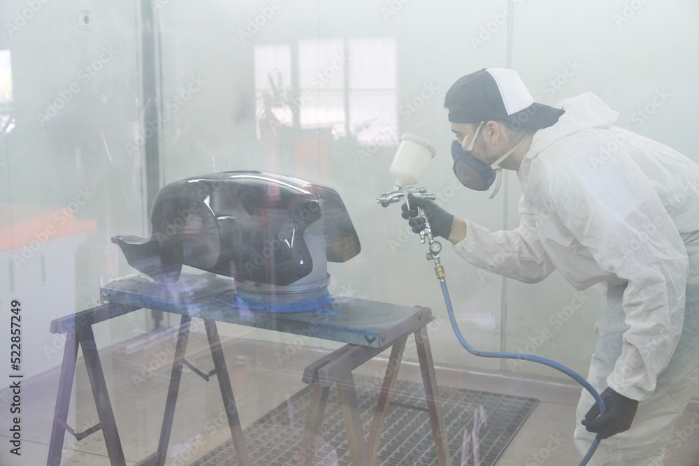 Through glass side view of professional male mechanic in protective ...