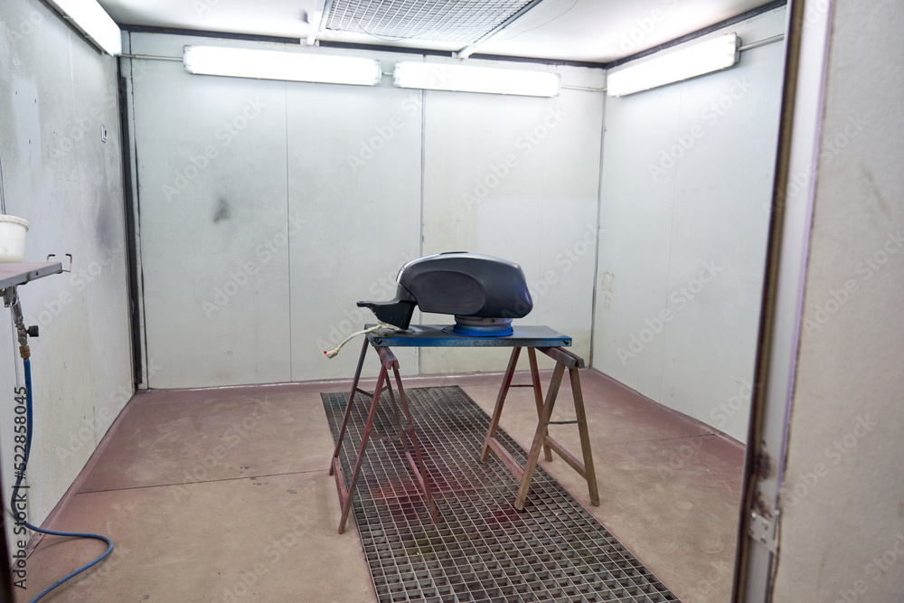 Motorbike fuel tank placed on metal workbench in professional workshop ...