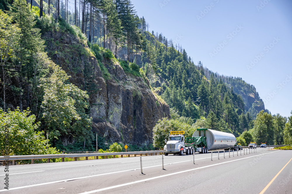 Big rig semi truck with oversize load sign transporting long oversized ...